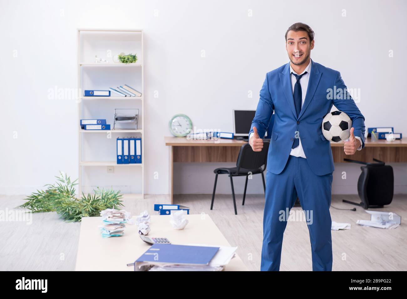 Young employee playing football in the office Stock Photo - Alamy