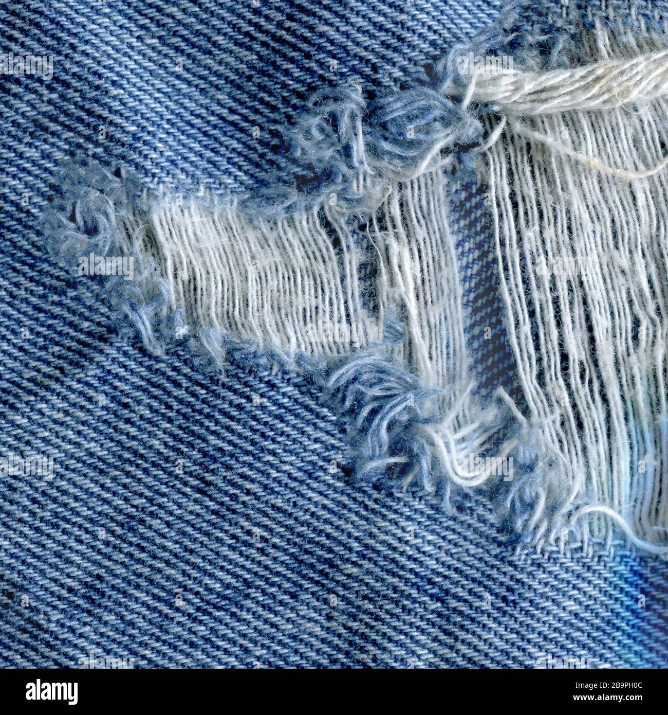 Blue torn grunge denim jeans texture. Jeans bit torn Stock Photo - Alamy