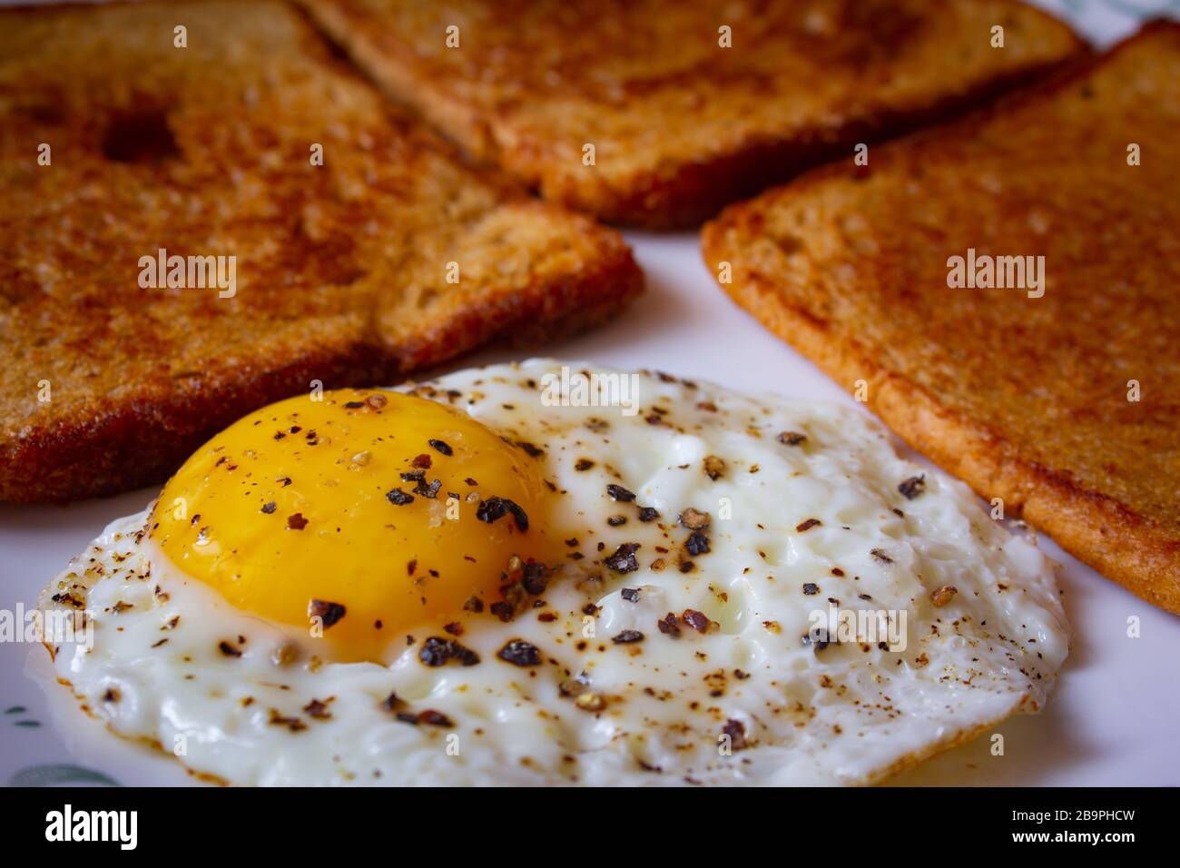 Butter toasted wheat bread with bulls eye egg. Sunny side up egg with ...