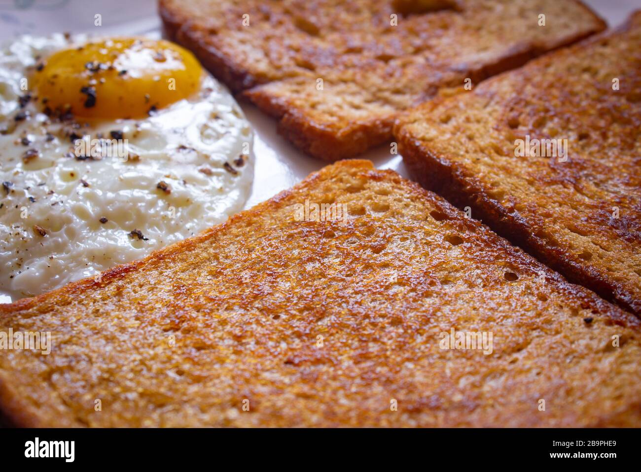 Butter toasted wheat bread with bulls eye egg. Sunny side up egg with ...