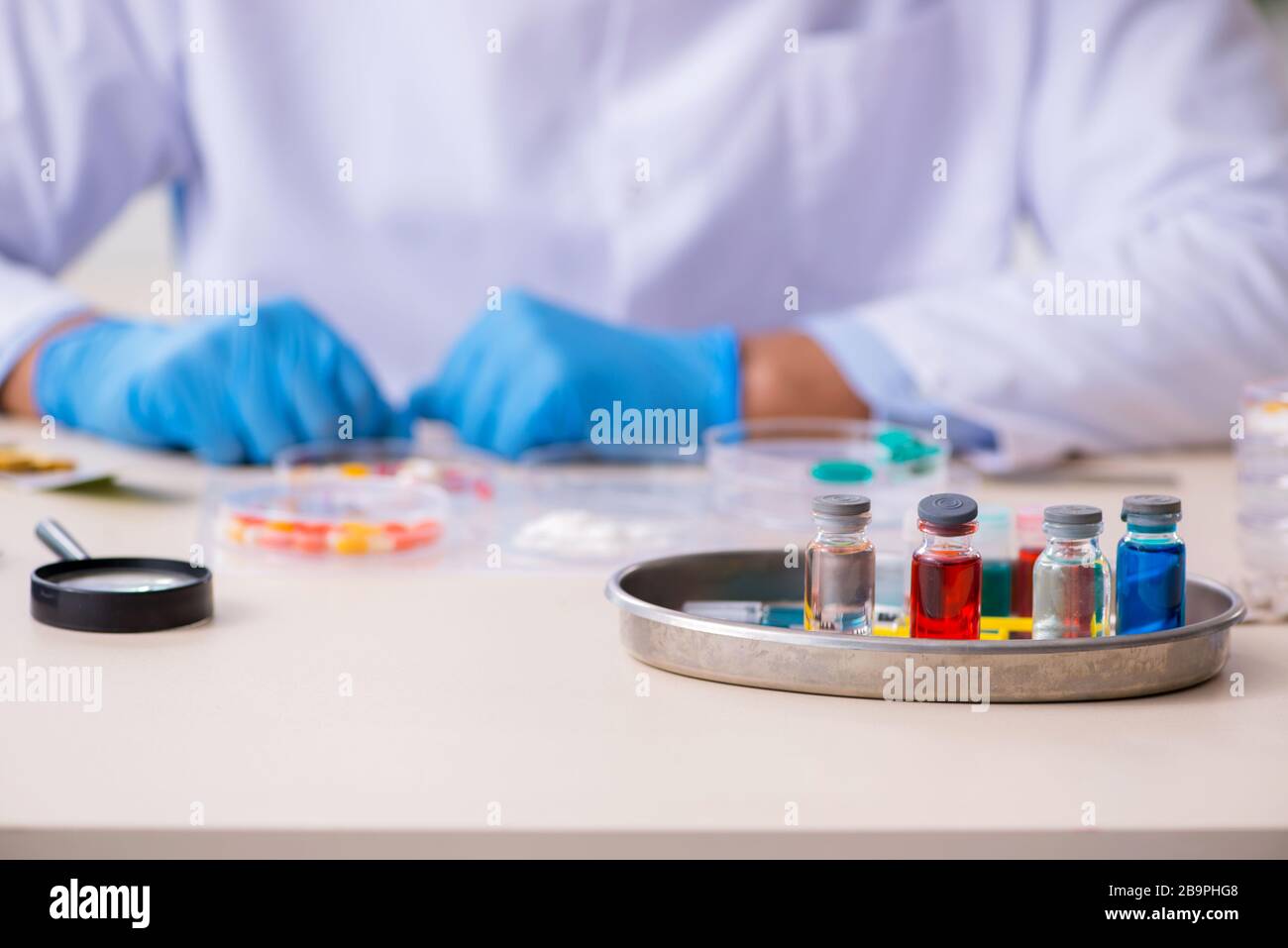 Young male lab assistant in the drug synthesis concept Stock Photo - Alamy