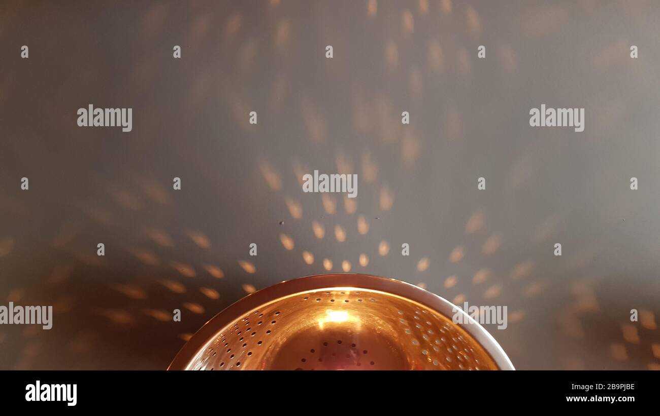 Lamp made from a colander. Soft shadows and lights. Abstract background ...
