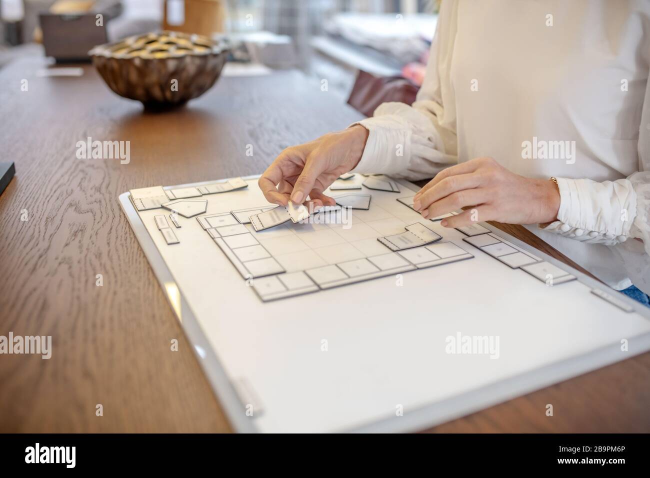 Female hands collecting interior layout of a room on a table Stock ...