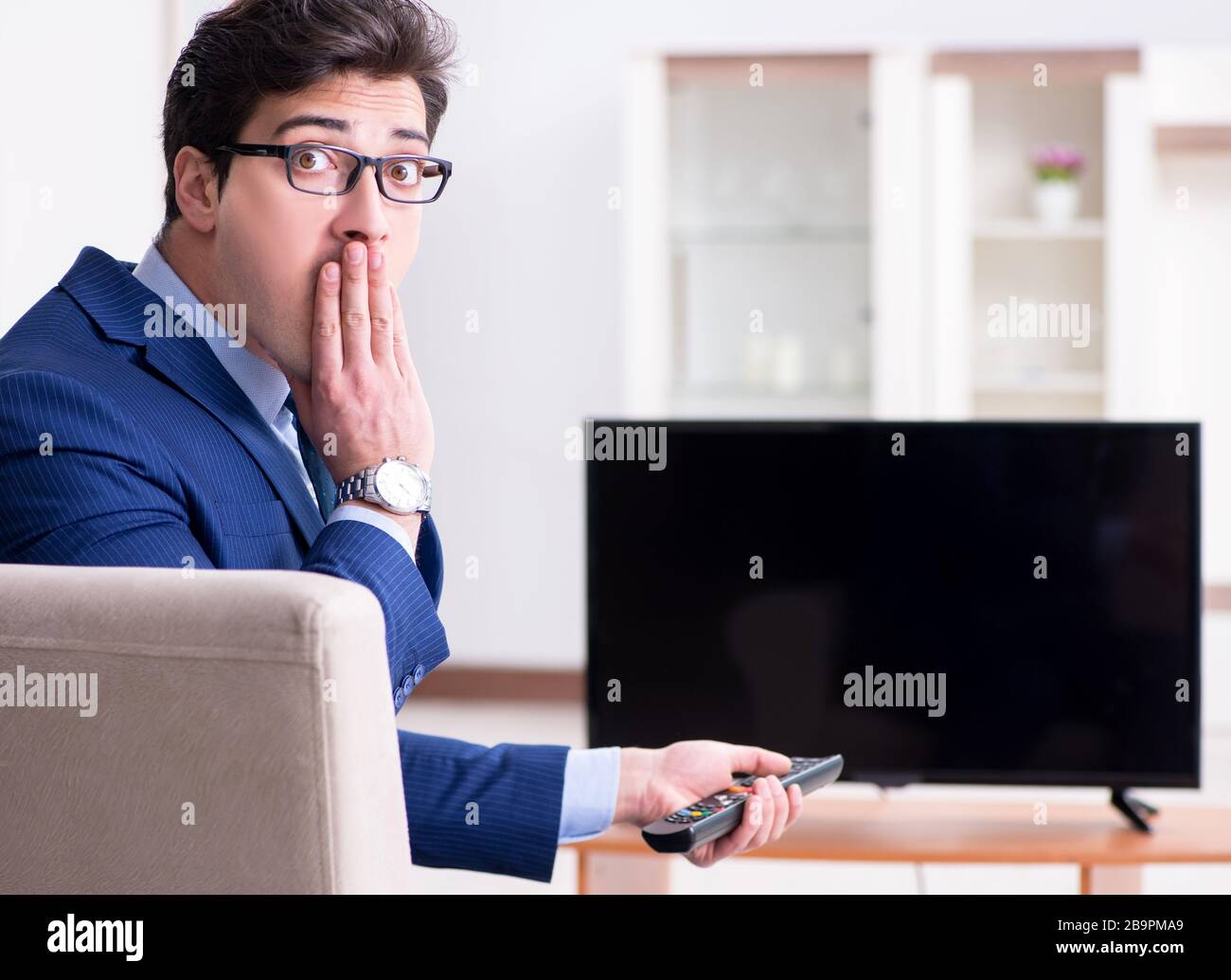 The businessman watching tv in the office Stock Photo - Alamy