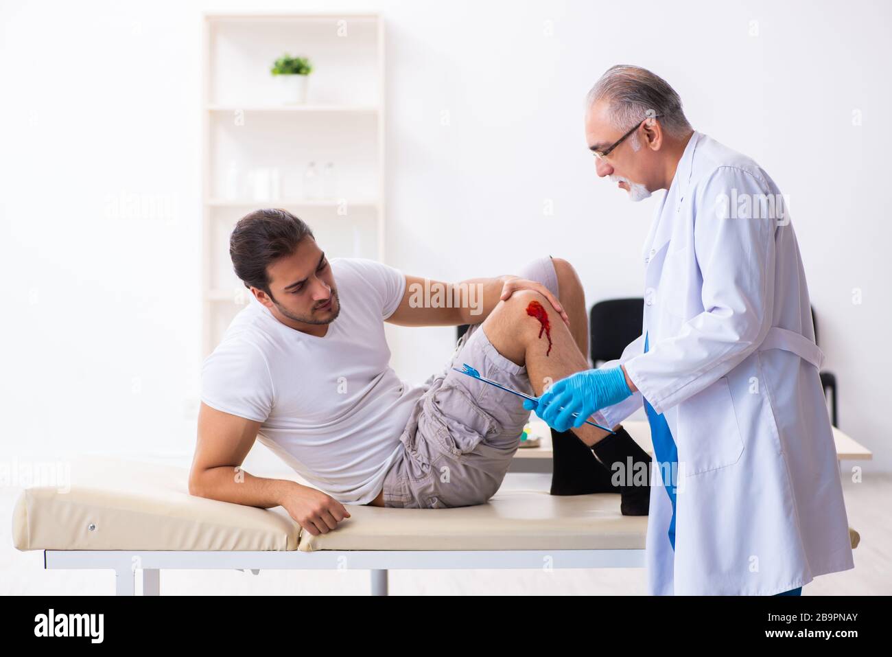 Leg injured man visiting doctor in first aid concept Stock Photo - Alamy