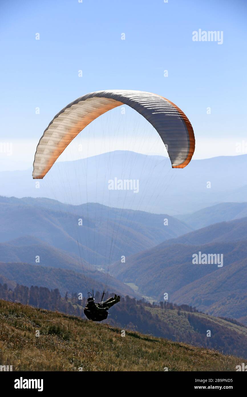 flying paraglider in air over mountain valley Stock Photo - Alamy