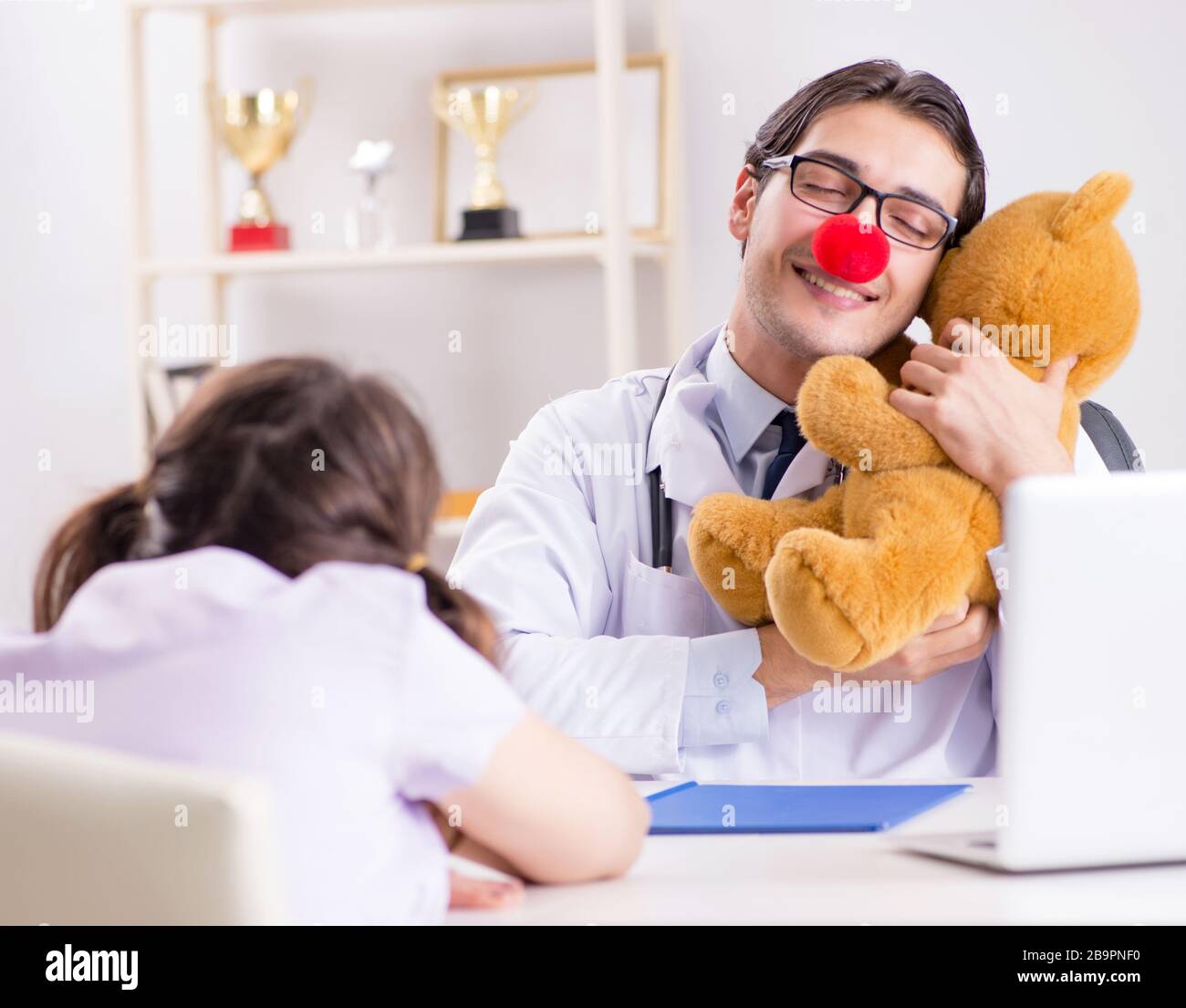 The funny pediatrician with little girl at regular check-up Stock Photo ...