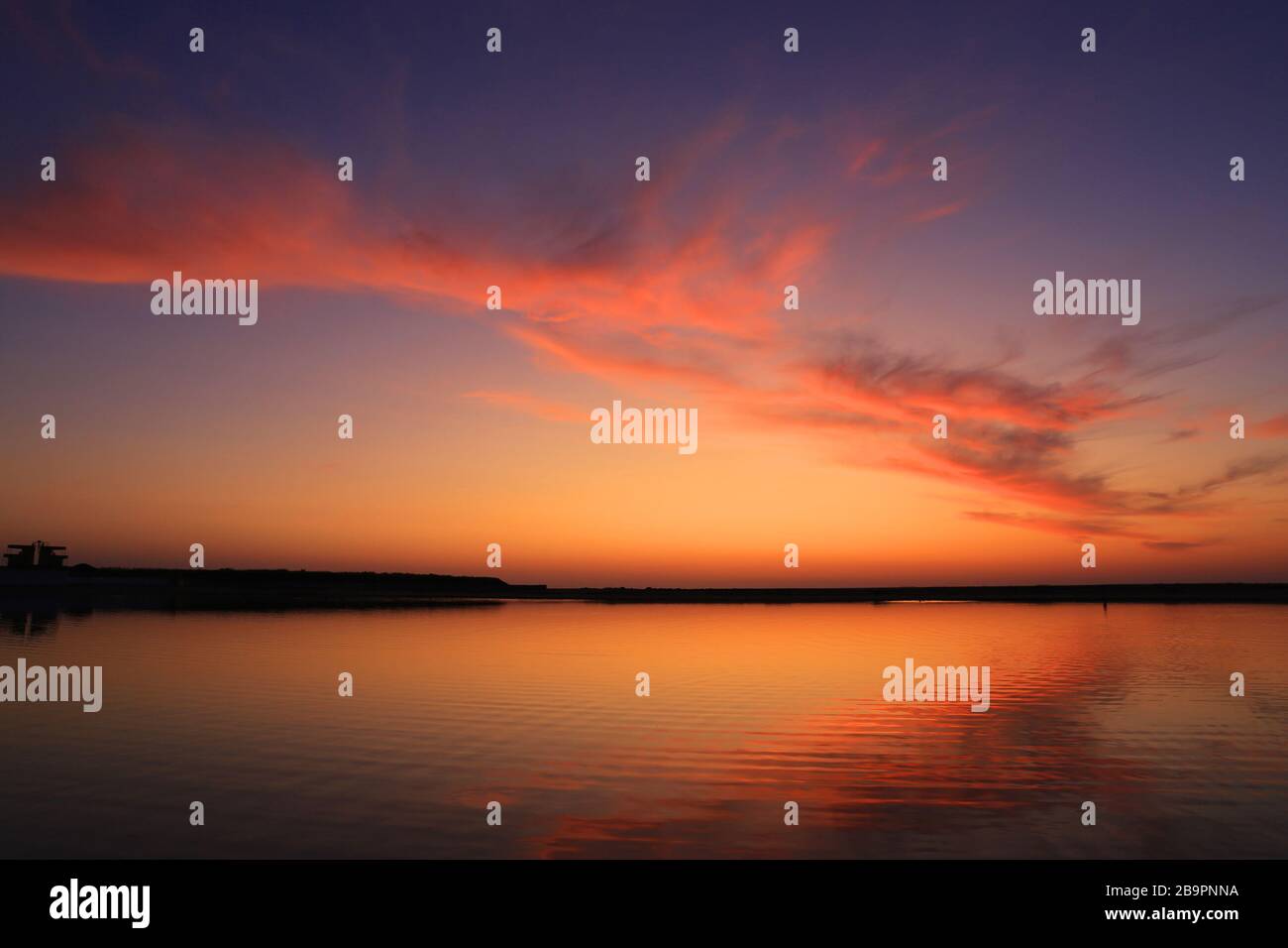 nice sunset landscape with red clouds in sky over lake water surface ...