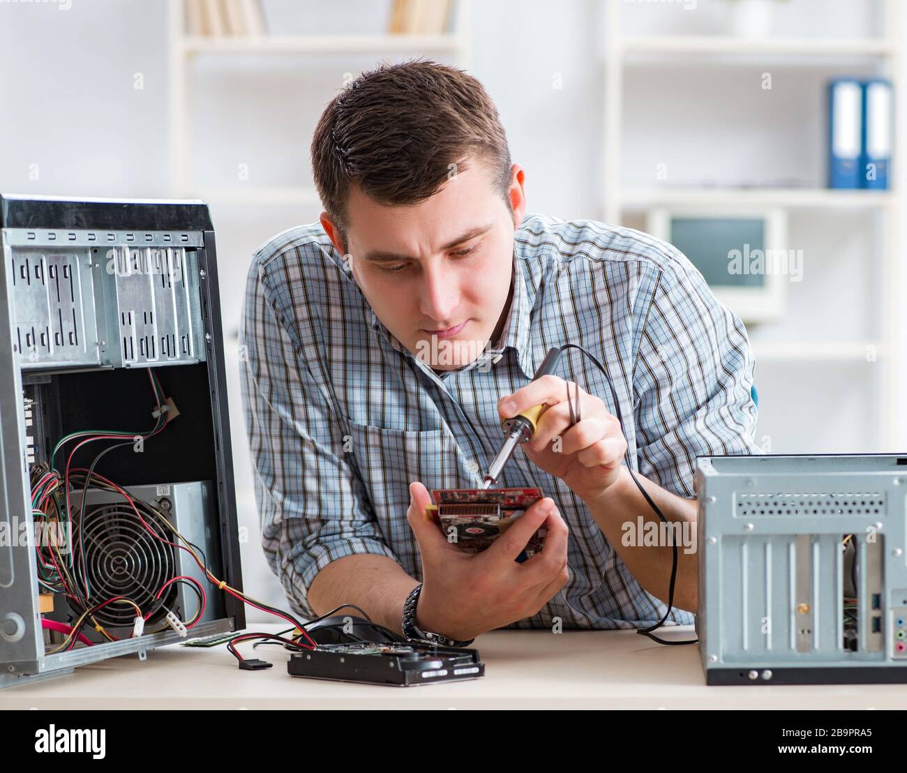 The young technician repairing computer in workshop Stock Photo - Alamy