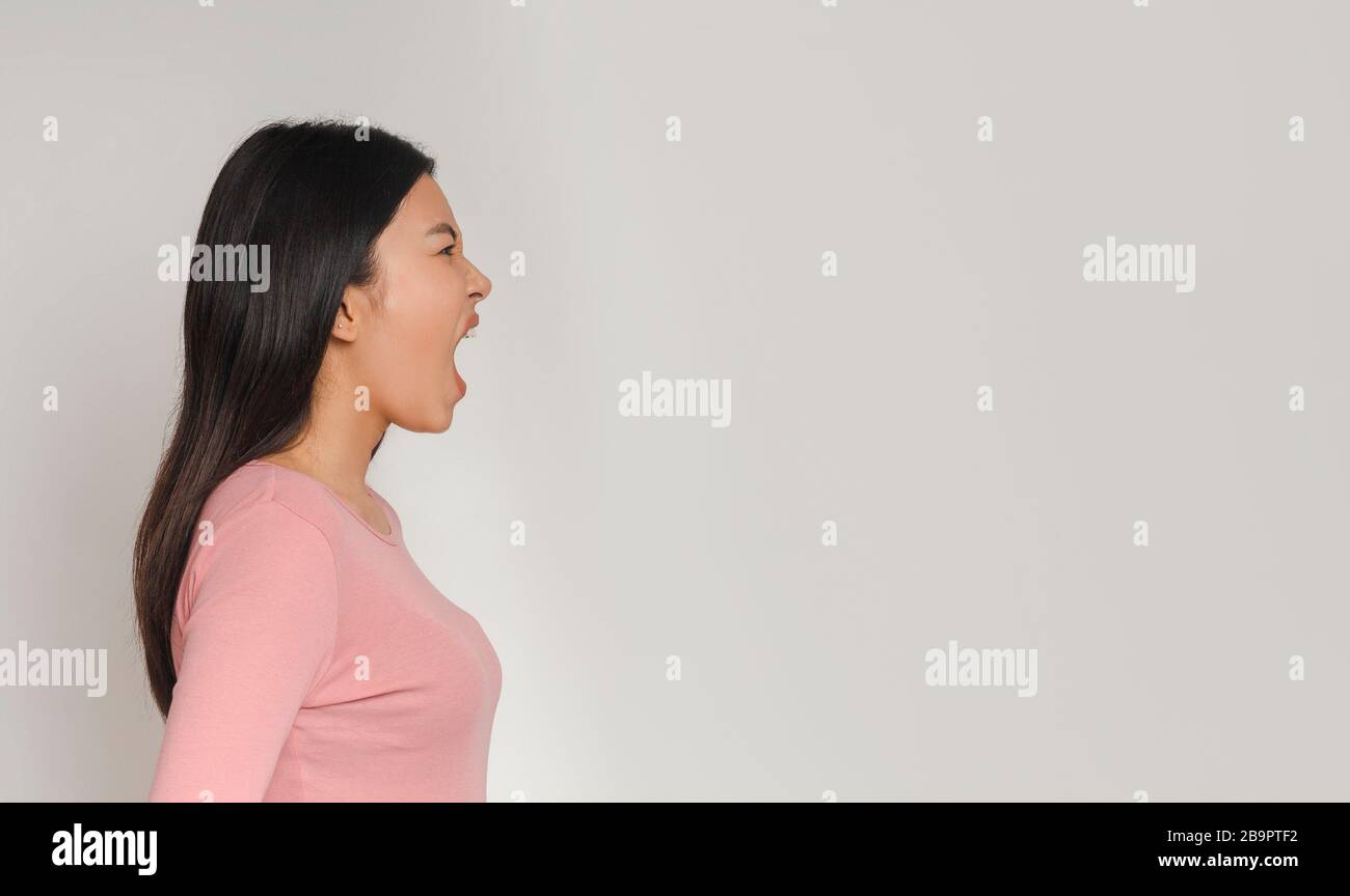 Side view of asian girl screaming towards copy space Stock Photo - Alamy