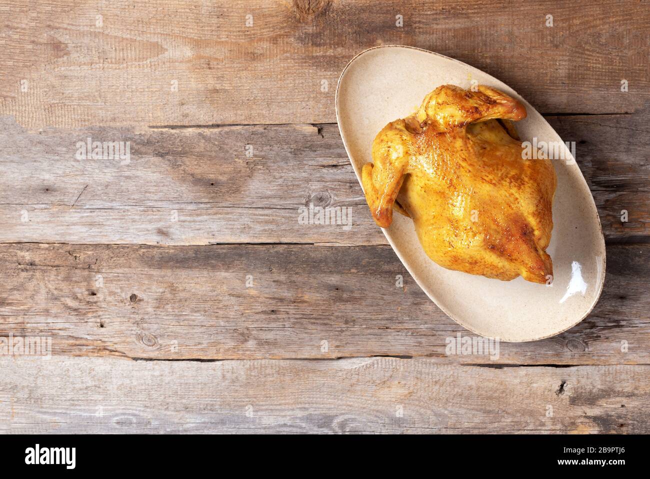 Whole roasted chicken on wooden background. Top view. Copy space ...