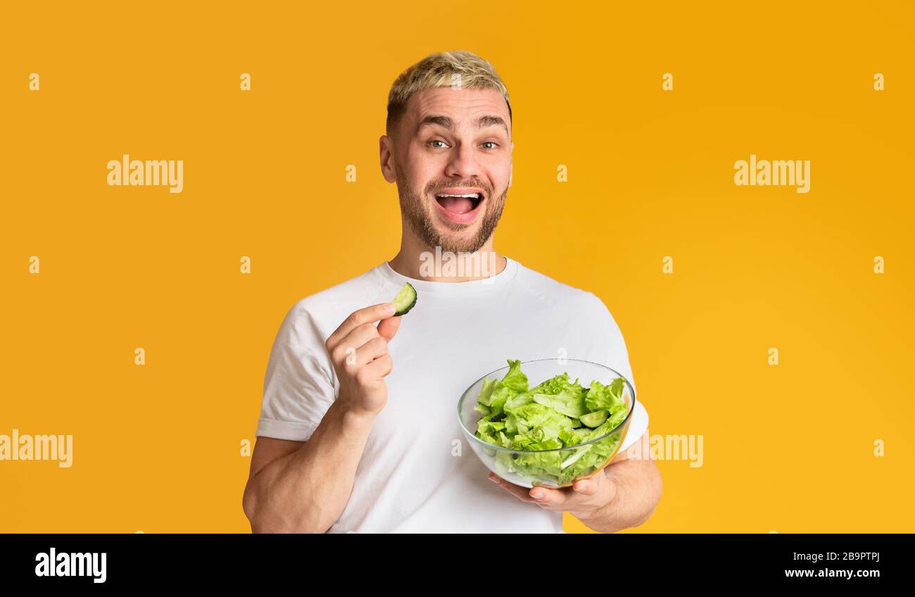 Man diet fun at studio. Happy guy eat vegetables Stock Photo - Alamy