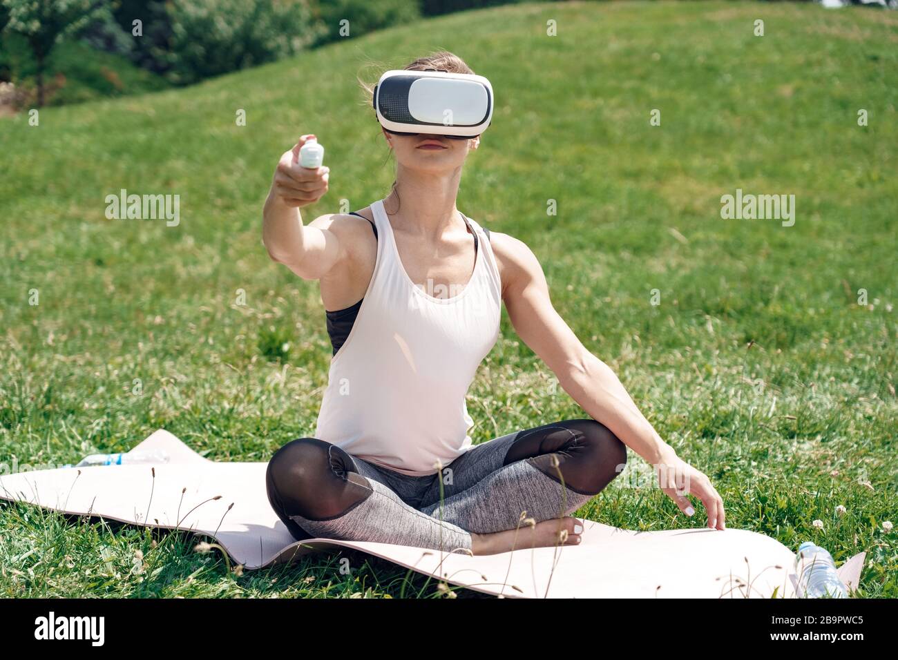 Healthy Lifestyle. Young woman outdoors sitting on mat practicing yoga ...