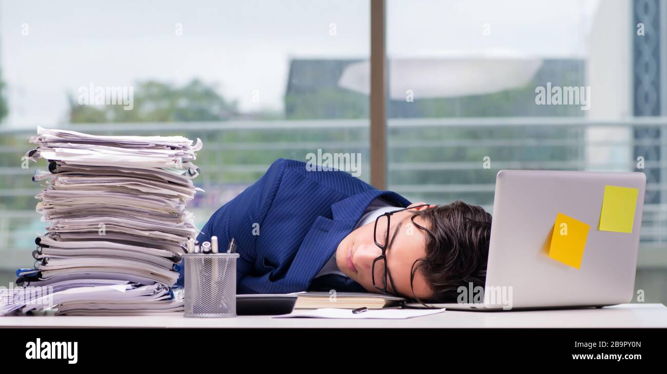 The workaholic businessman overworked with too much work in office ...