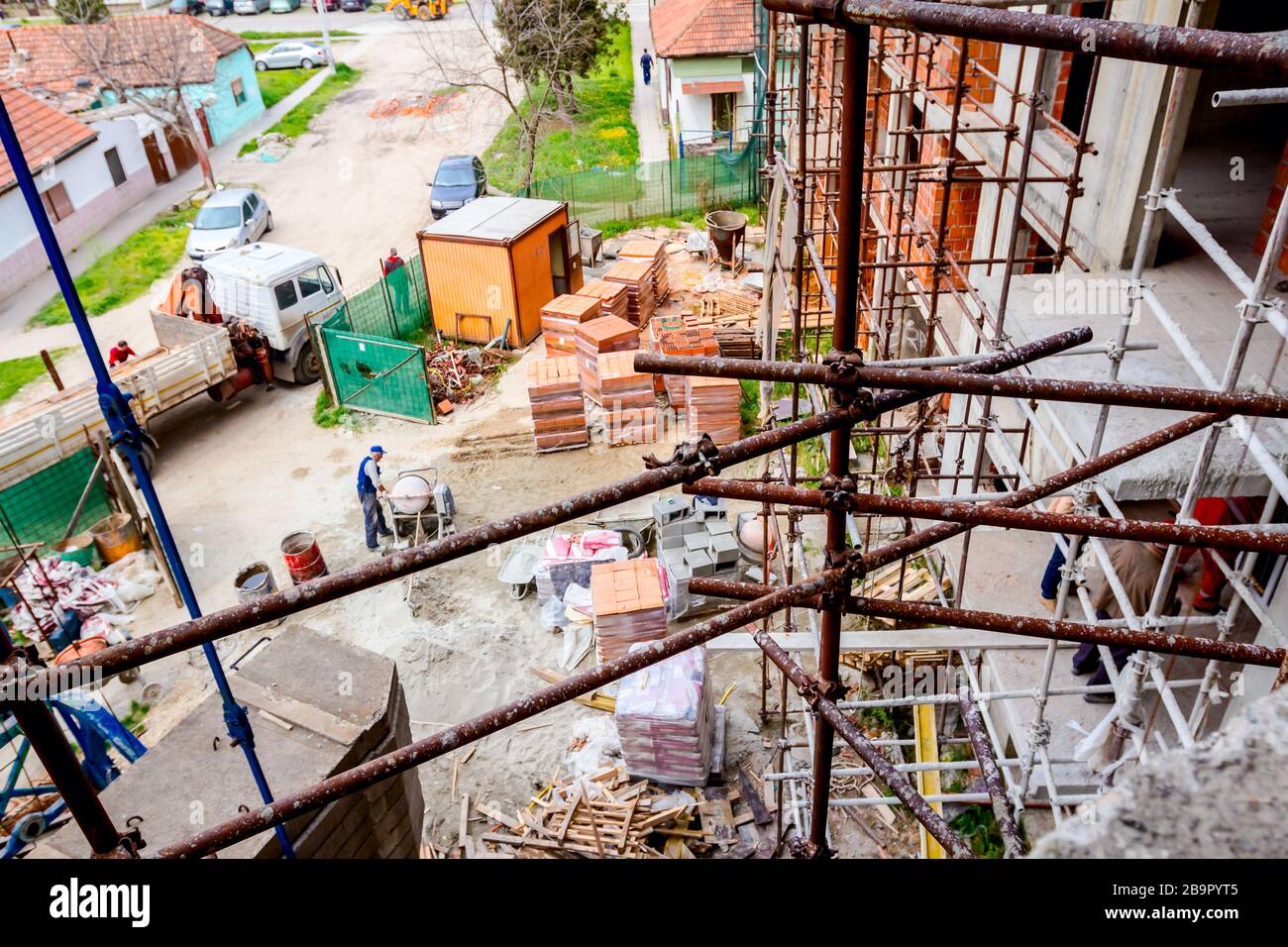 Rusty scaffold is placed against edifice, building under construction ...