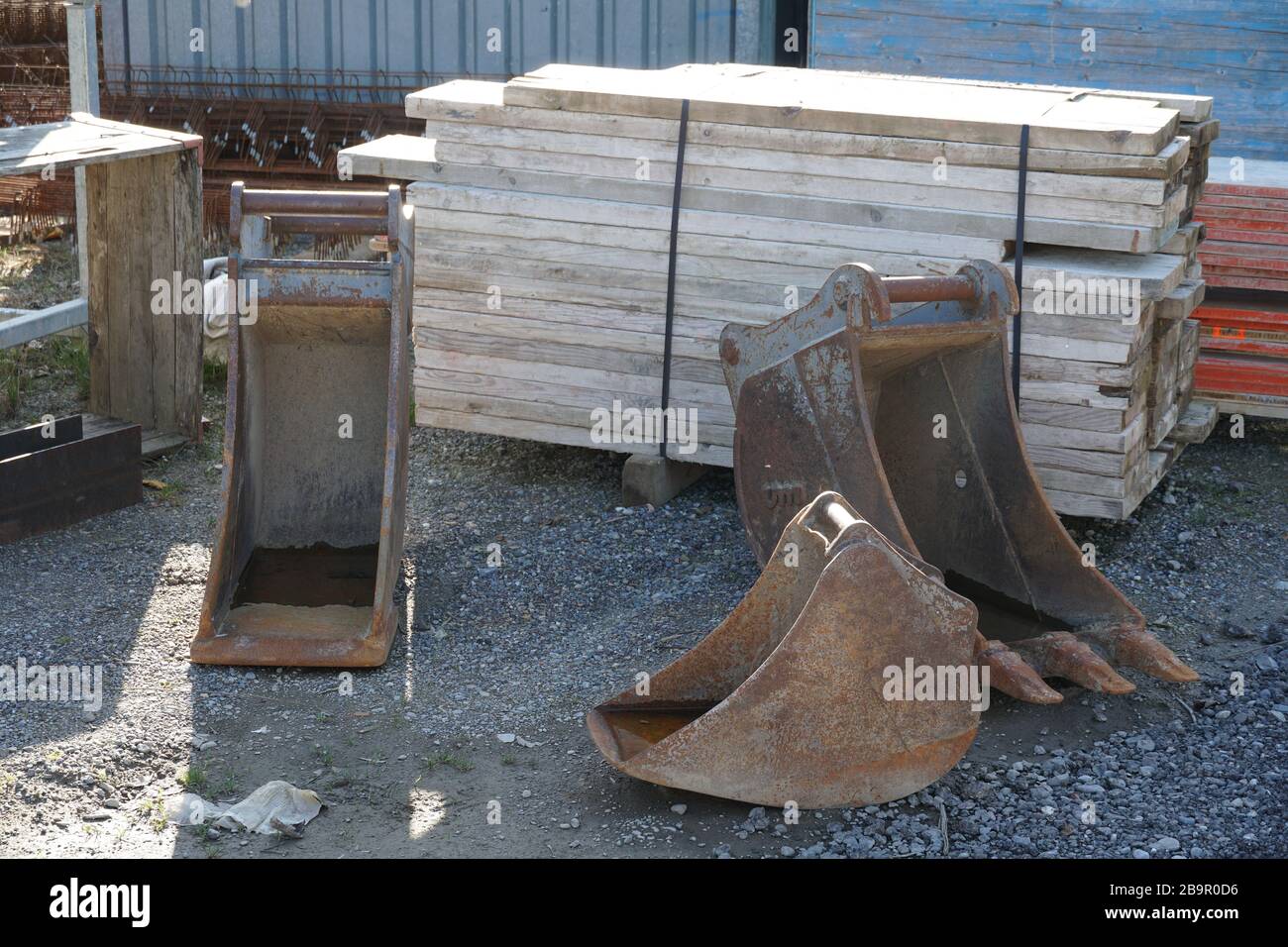 a pile of rectangular concrete plates and severals bulldozer dipper ...