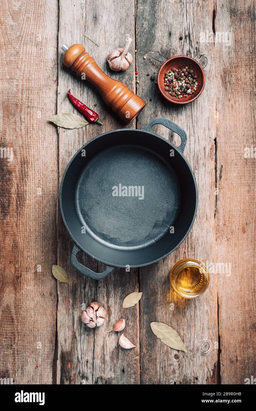 Empty iron pot and kitchen utensils on wooden background. Top view ...