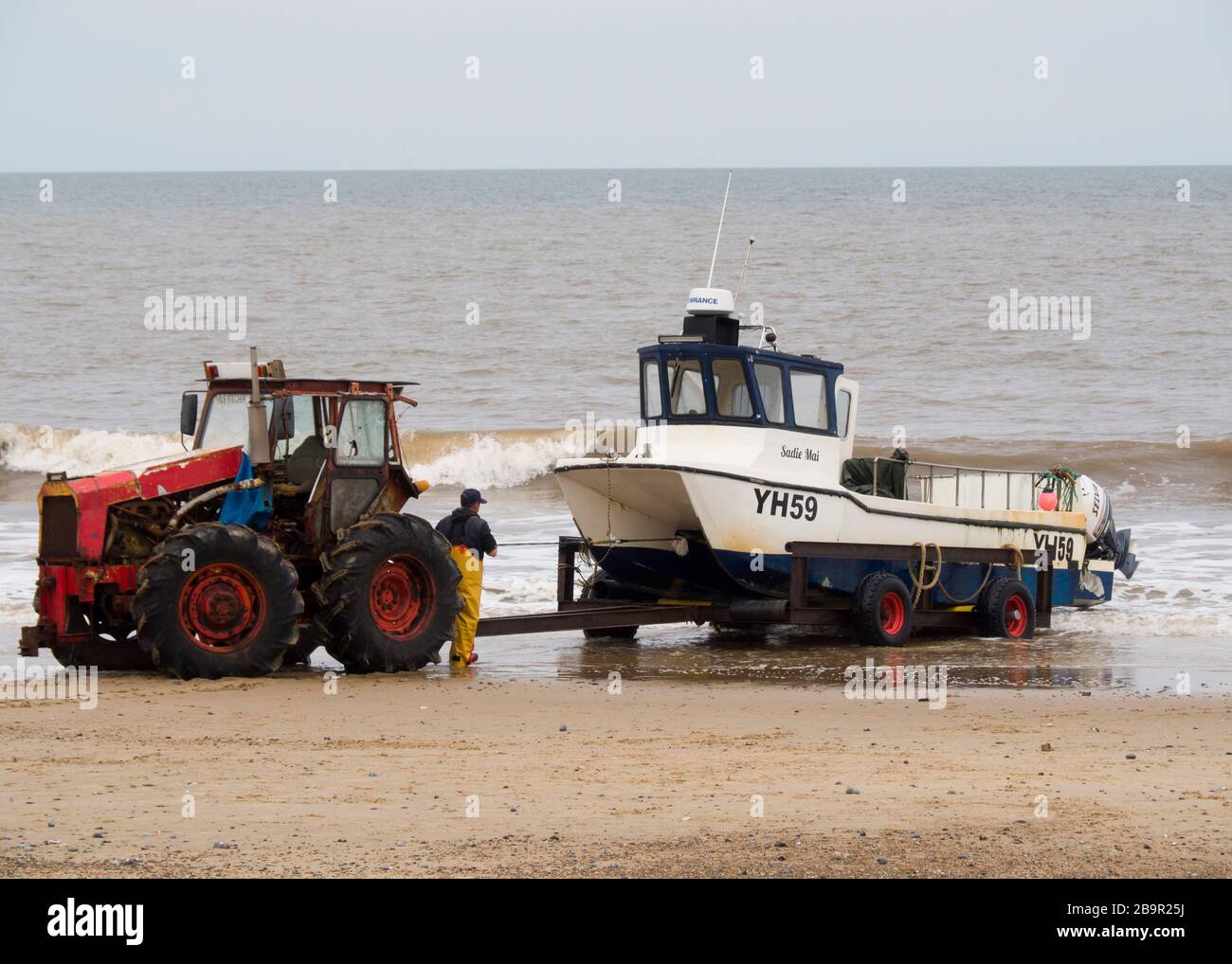 Cromer fisherman loading boat onto tractor and trailer, Cromer, Norfolk ...