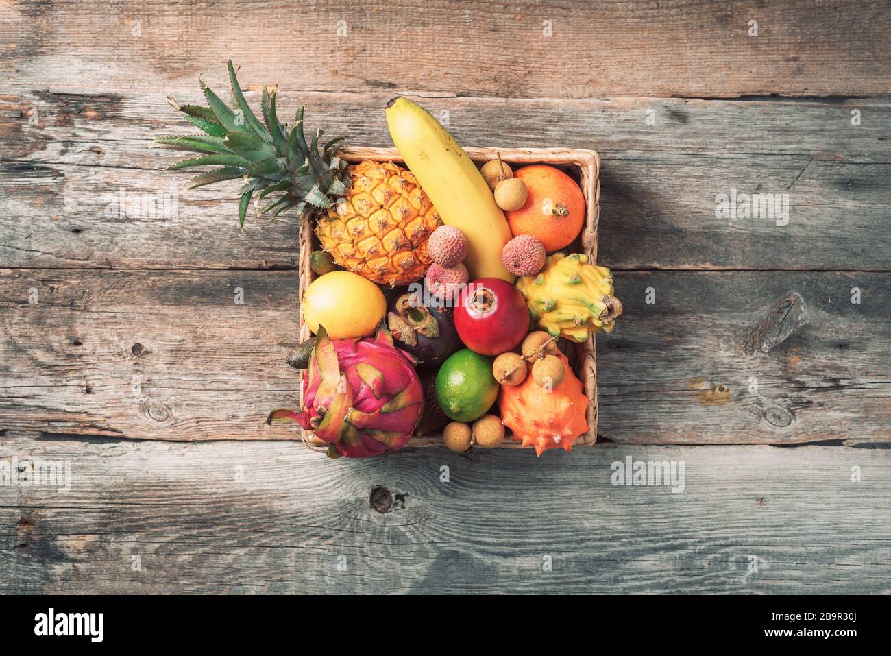 Rattan box full of exotic thailand fruits - pineapple, pitahaya, kiwano ...