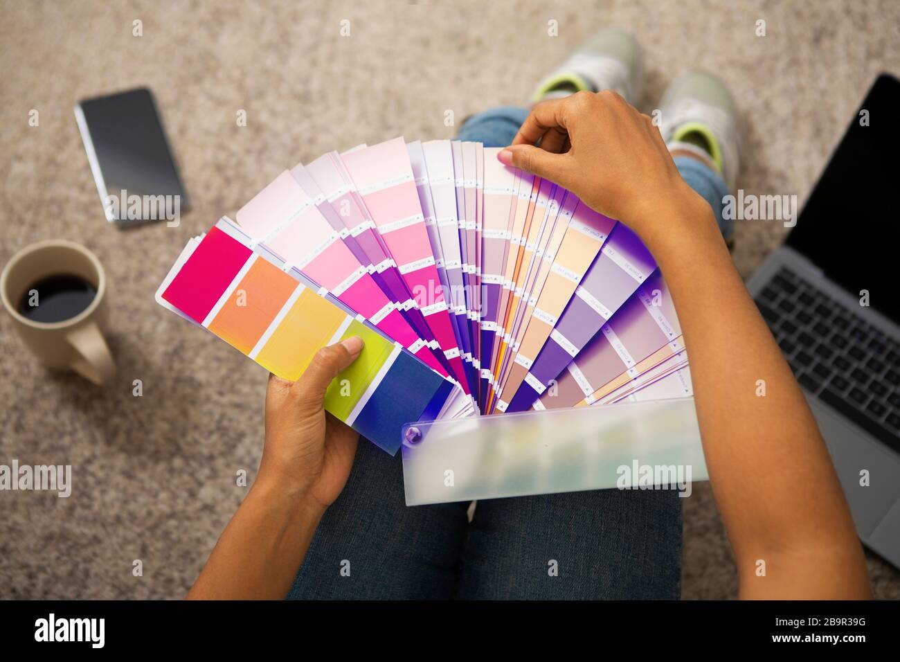 Girl choosing bright paint using color swatch Stock Photo - Alamy