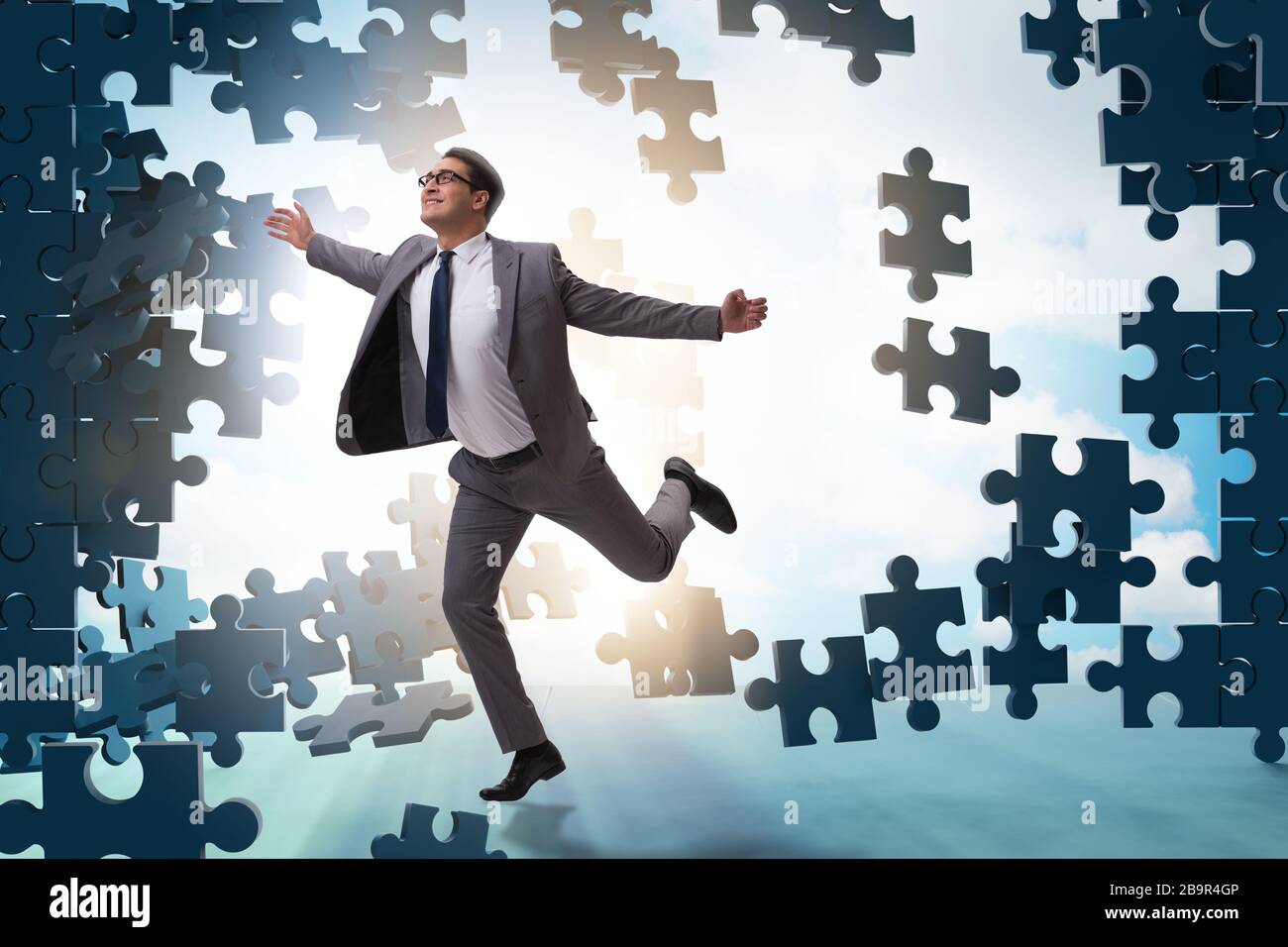 Businessman breaking wall of jigsaw puzzle Stock Photo - Alamy