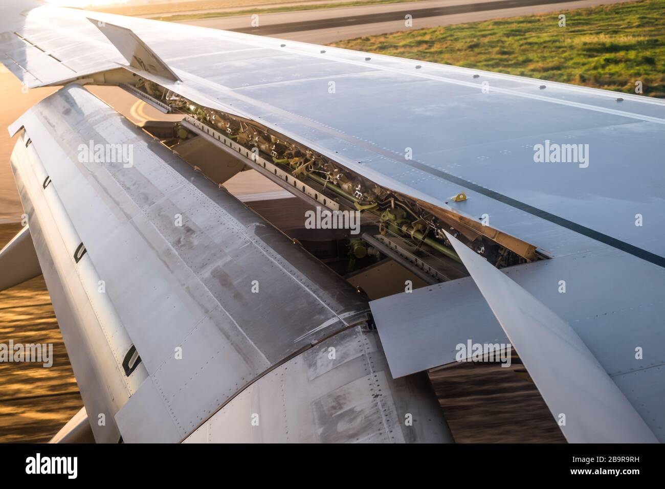 airplane window view of wing and flaps after landing at the airport ...