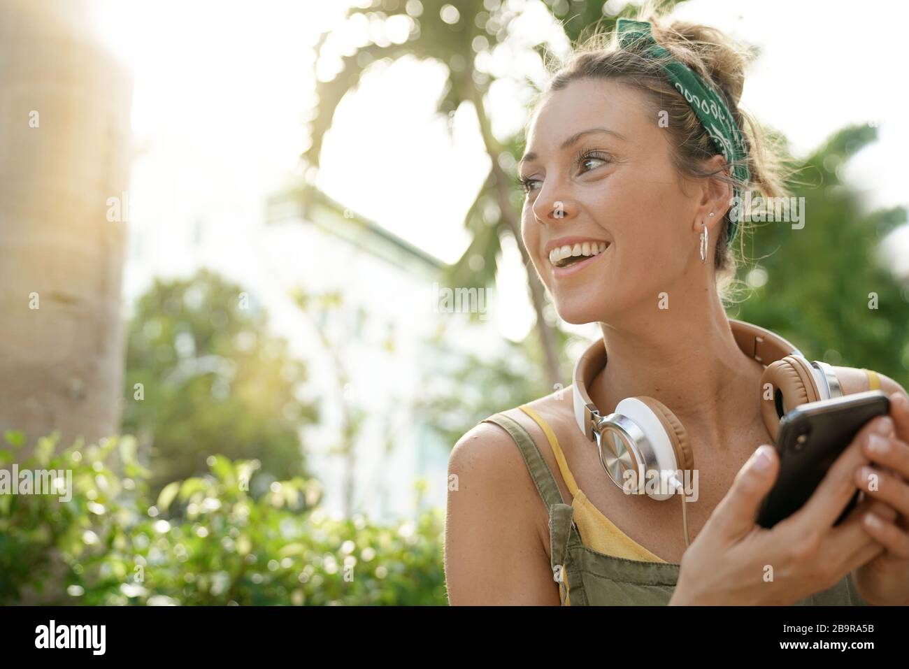 Young stylish traveller smiling and on her phone Stock Photo - Alamy