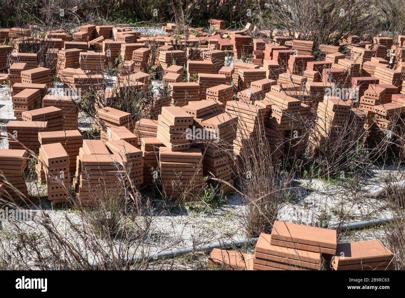 red thermal bricks thrown on the old asphalt Stock Photo - Alamy