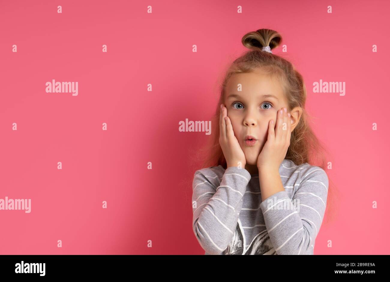 Little blonde model with bun hairstyle, dressed in gray striped blouse ...