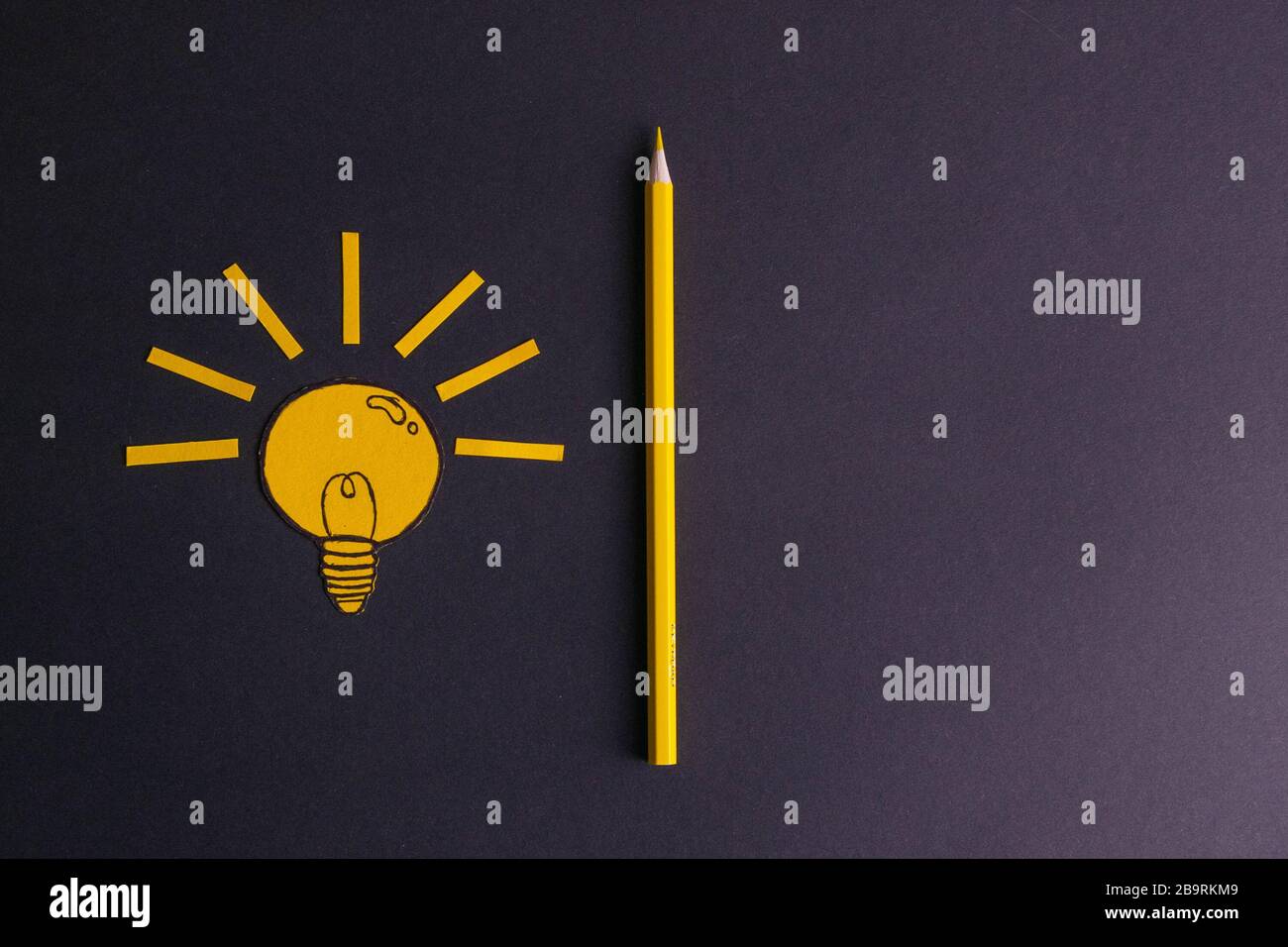 A yellow pencil next to a creative painted light bulb. The concept of ...