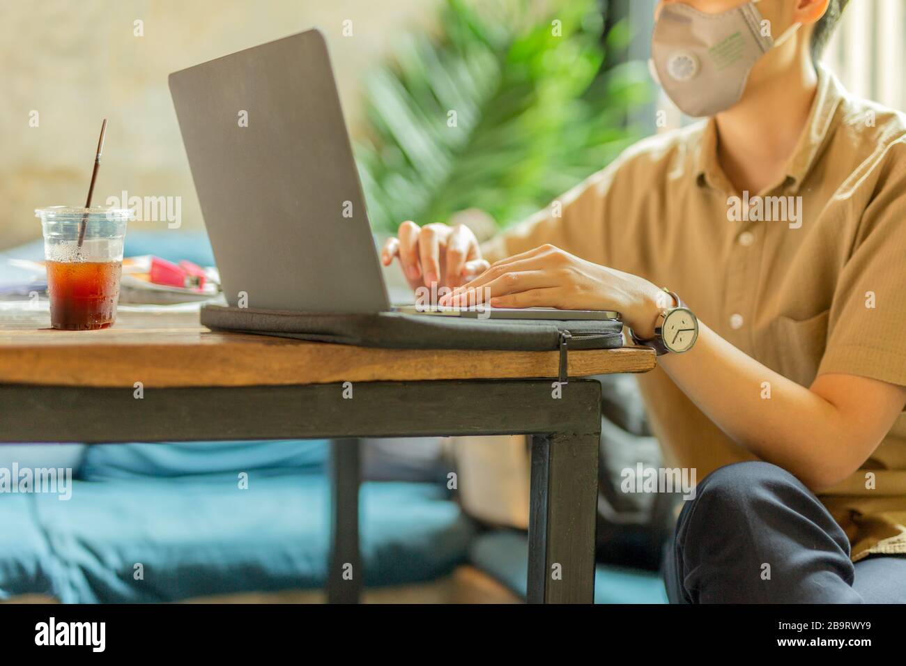 Woman in protective mask working on laptop in cafe Stock Photo - Alamy