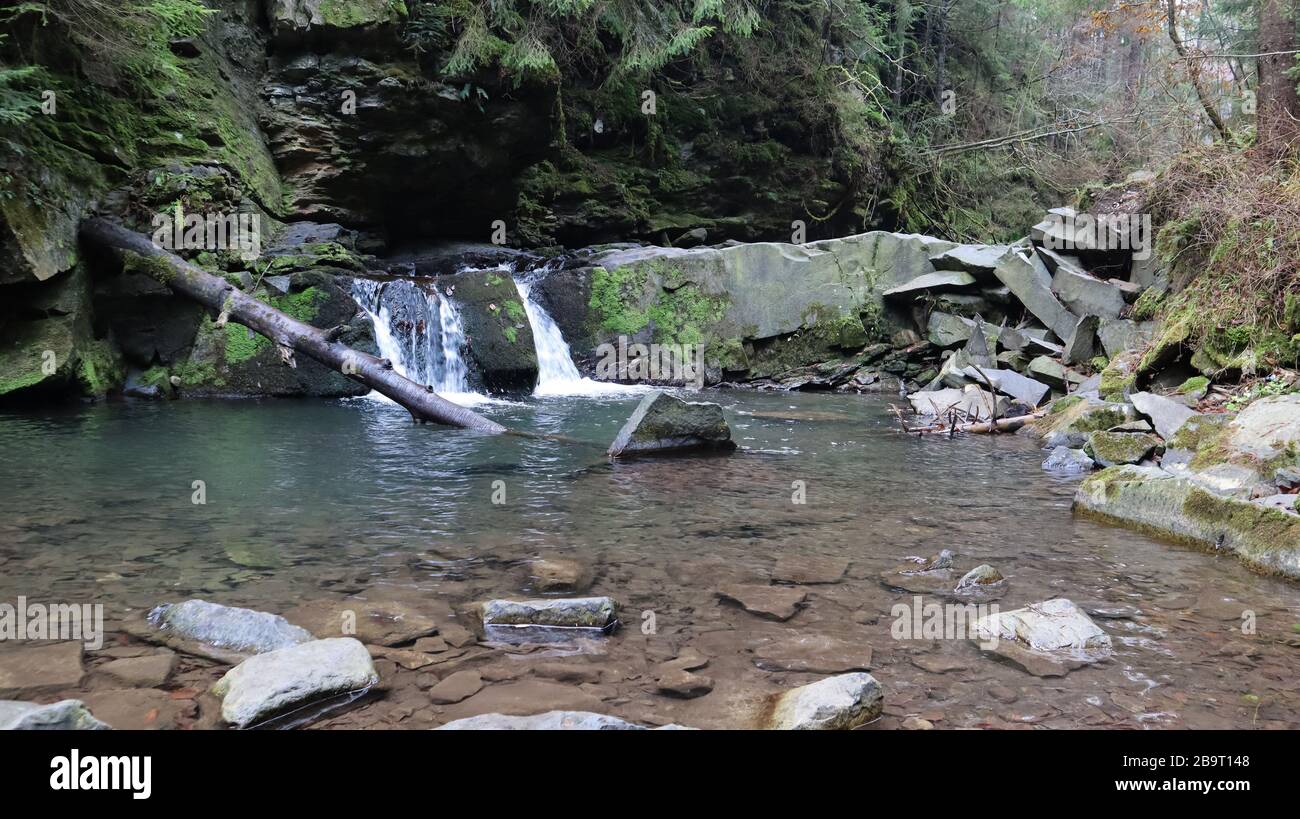 Waterfalls in a small canyon with stone walls. Beautiful cascade in the ...