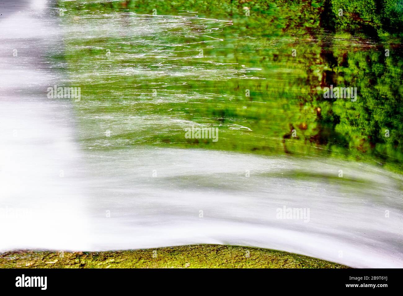 Fast flowing water in a bright green stream in Canterbury, England,UK ...