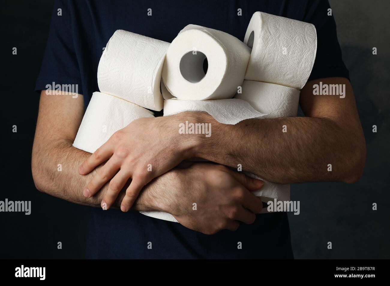 Man holds rolls of toilet paper, front view Stock Photo - Alamy