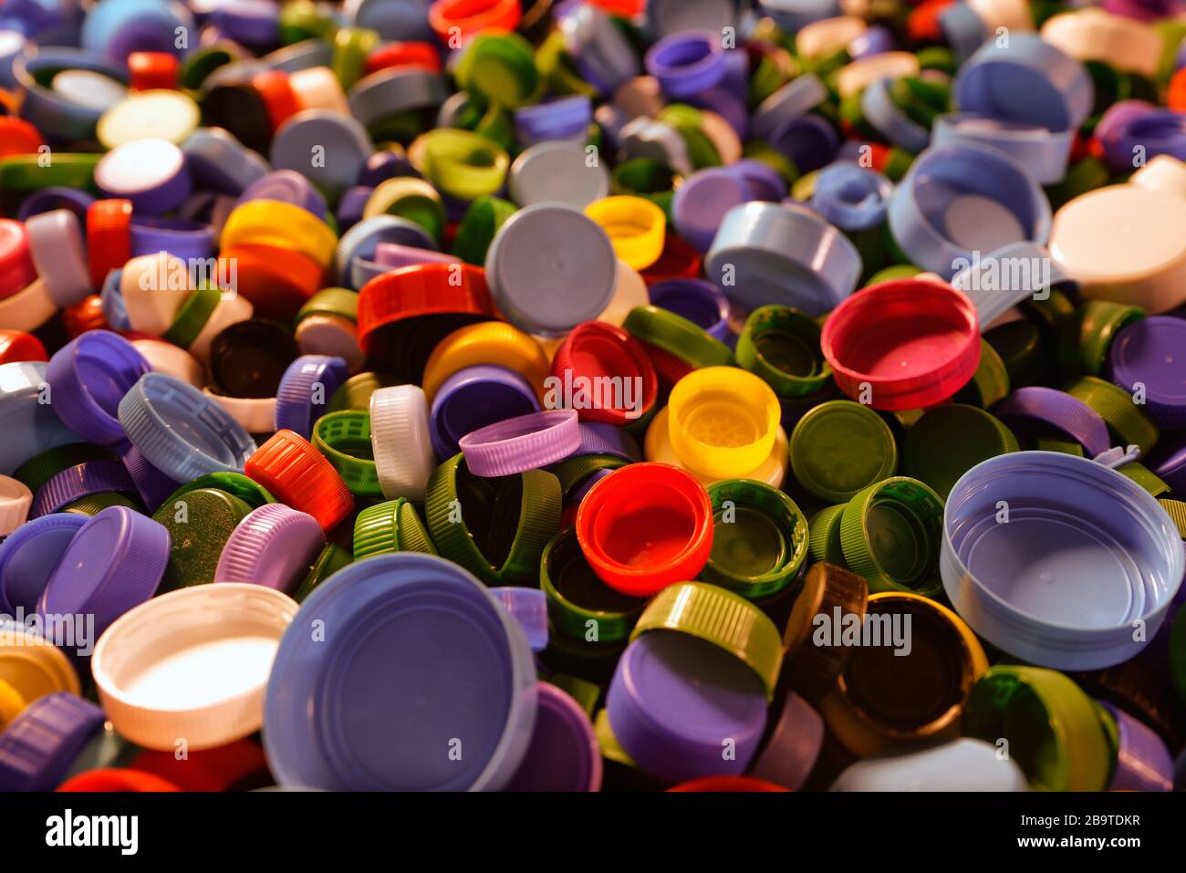 Sorting impressive number of colorful bottle plastic caps spread and ...