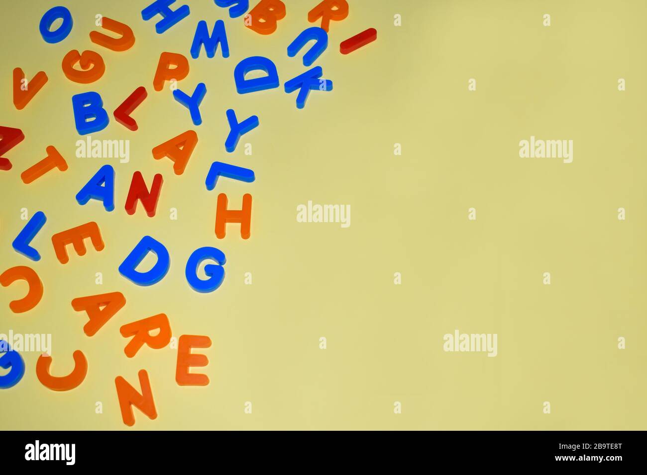 different colored letter blocks scattered over a single yellow paper ...