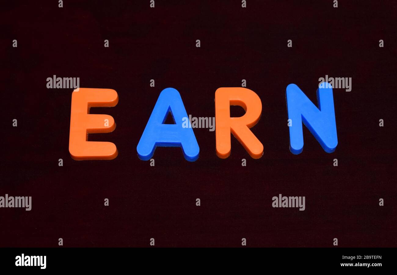 Earn word written with different colored letter blocks arranged on a ...
