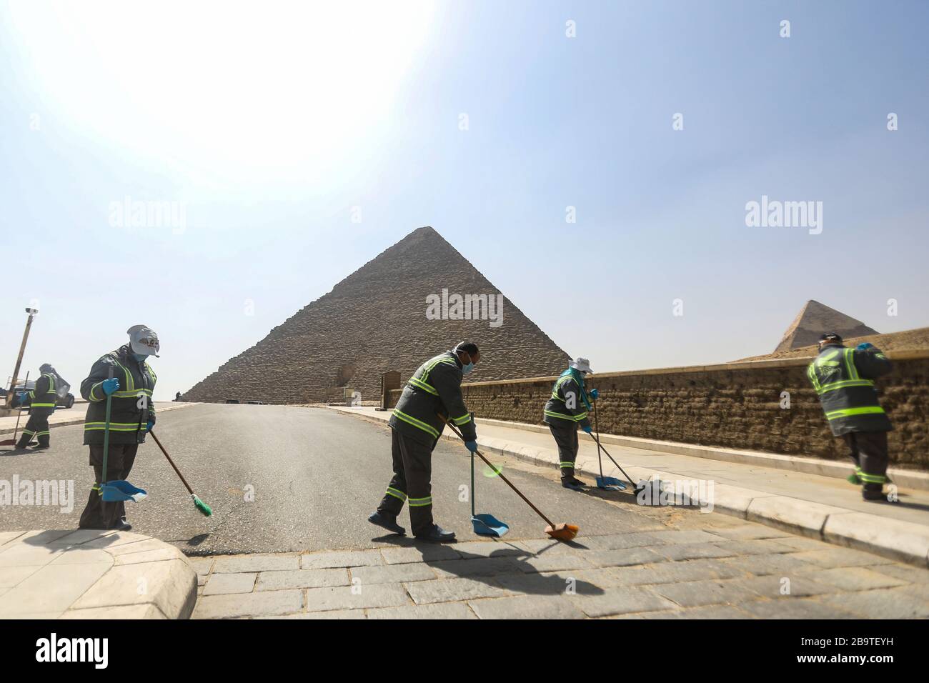 Giza, Egypt. 25th Mar, 2020. Workers take part in a cleaning and ...