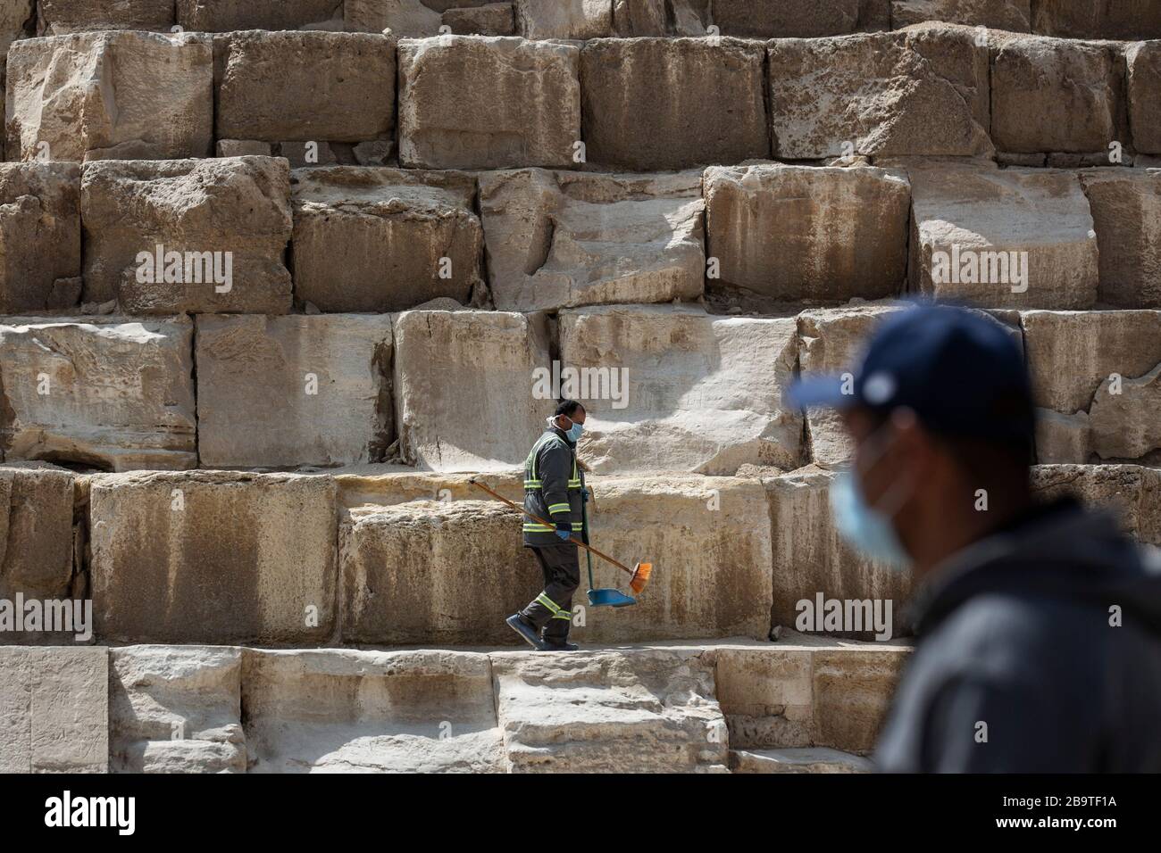 Giza, Egypt. 25th Mar, 2020. A worker takes part in a cleaning and ...