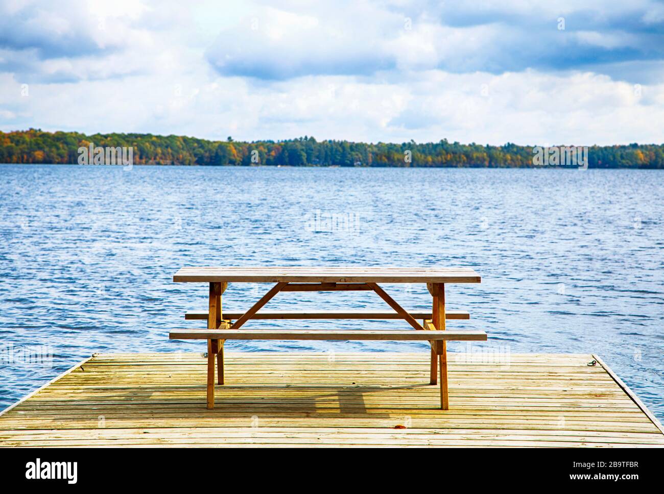 Empty footbridge with a bench on a lake Stock Photo - Alamy