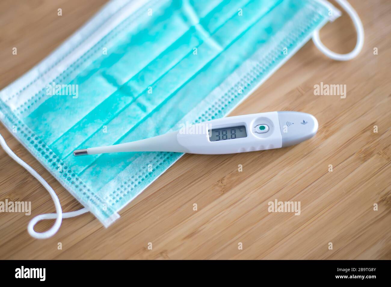 Surgical ear-loop mask and thermometer on the table Stock Photo - Alamy