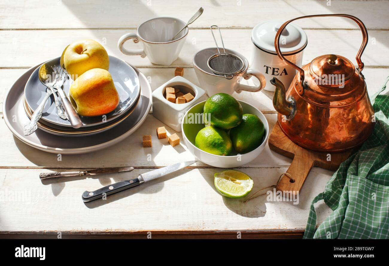 Kitchen still life with copper kettle, ceramic utensils and fruits in ...
