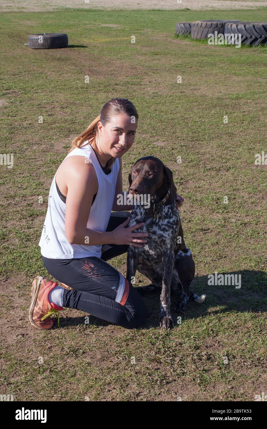 A portrait of a sporty woman with her Short Haired German Pointer dog ...