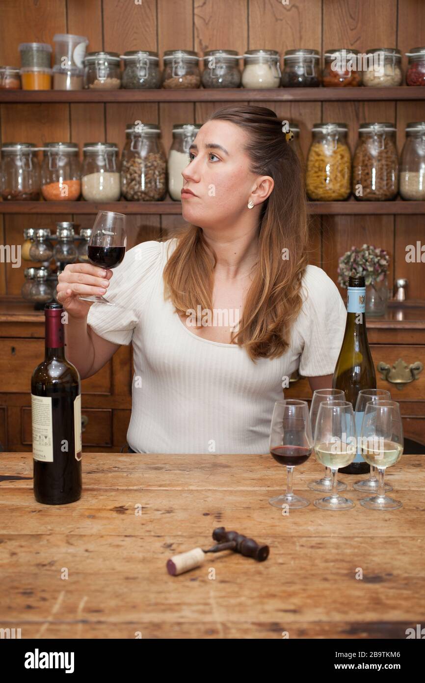 A female wine taster sampling a glass of red wine Stock Photo - Alamy