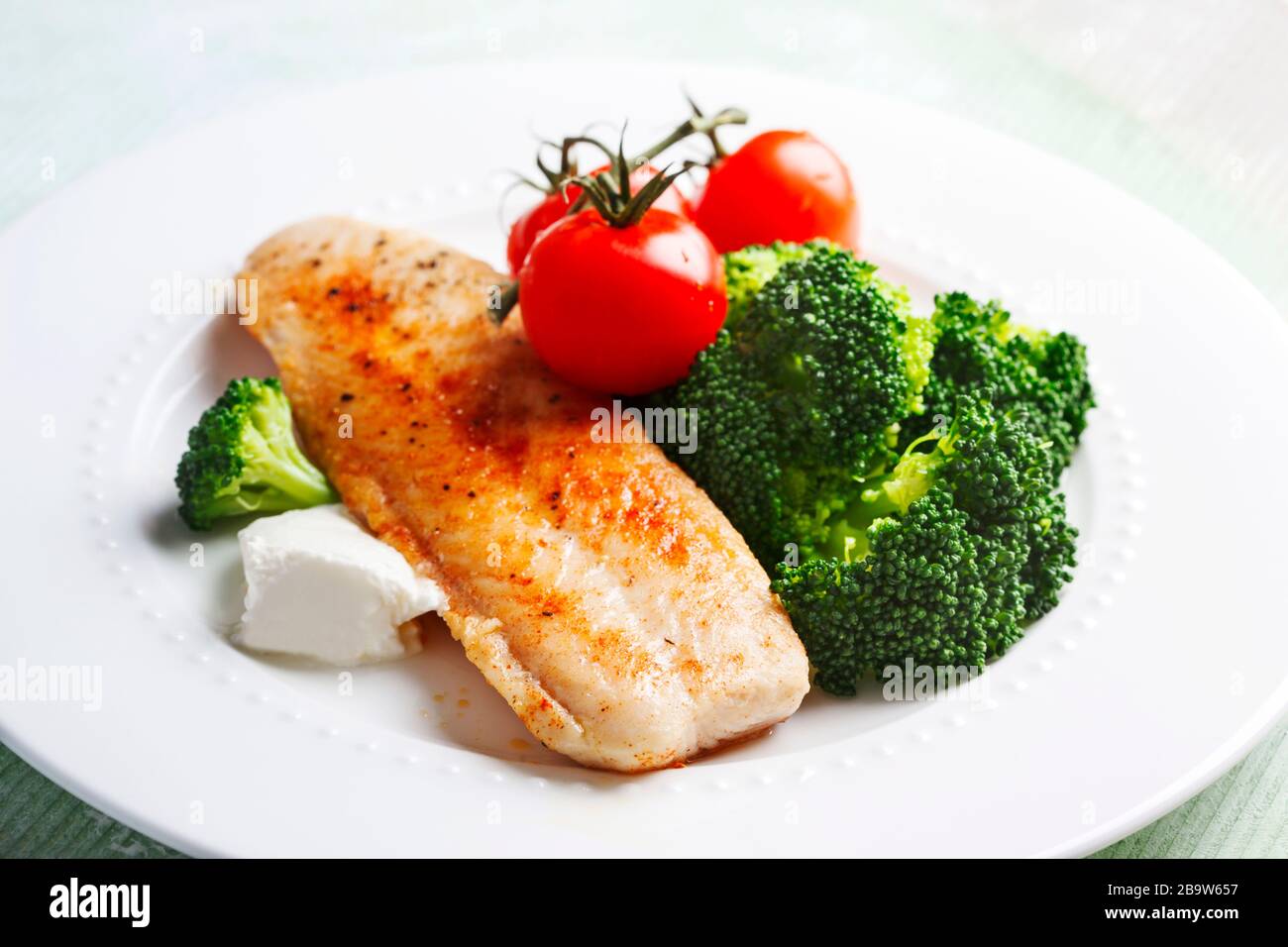 Fried Basa Fillet with sauce, broccoli and fresh tomato Stock Photo - Alamy