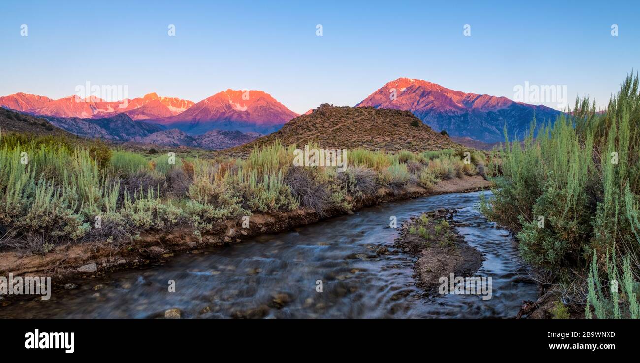 Beautiful scenery of a river surrounded by bushes and mountains Stock ...
