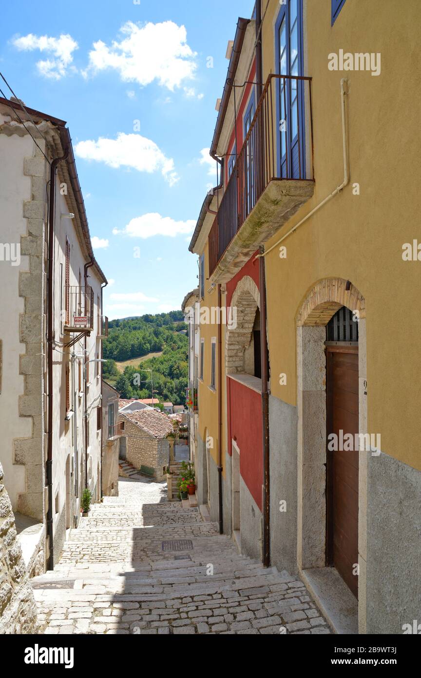A narrow street between the old houses of Sepino, a medieval village in ...