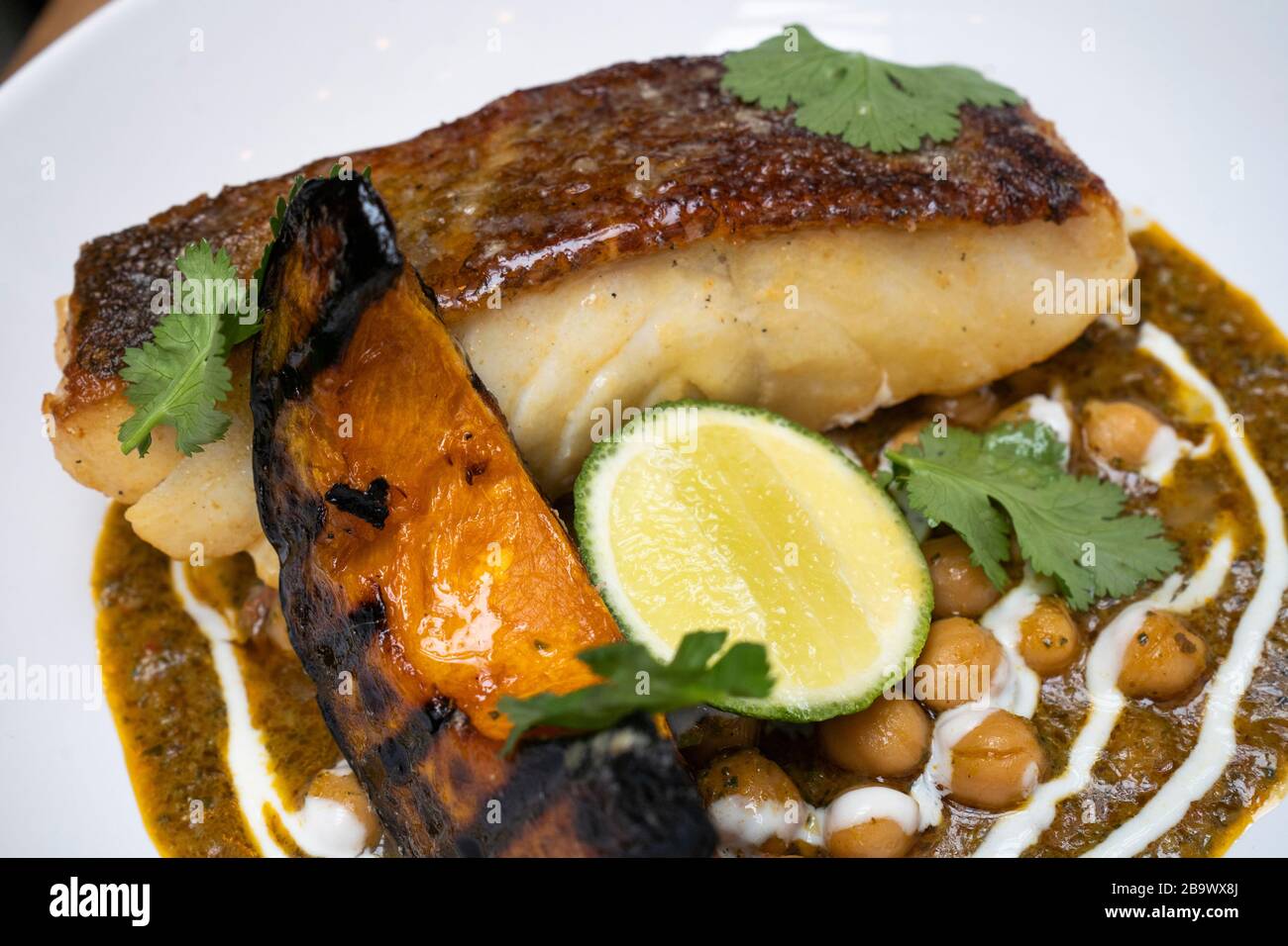 Roast curry cod, delica pumpkin and chickpea masala Stock Photo - Alamy
