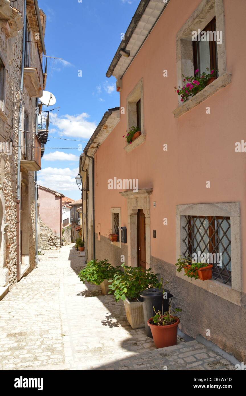 A narrow street between the old houses of Sepino, a medieval village in ...