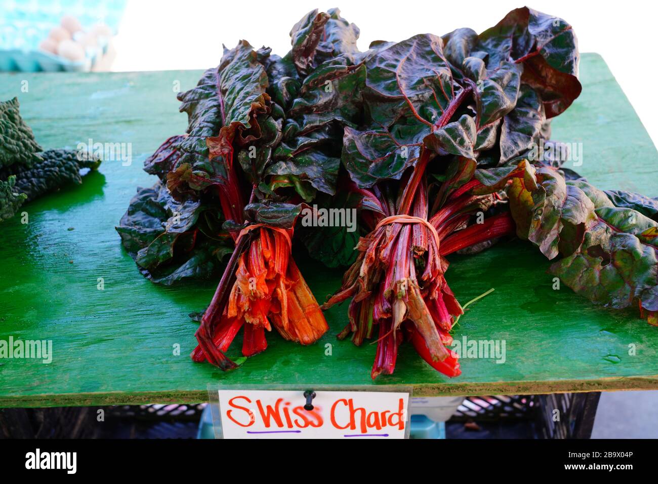 Bunches of rainbow Swiss chard with bright red and orange stalks and ...